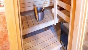 Uma sauna de madeira com bancos e um balde.