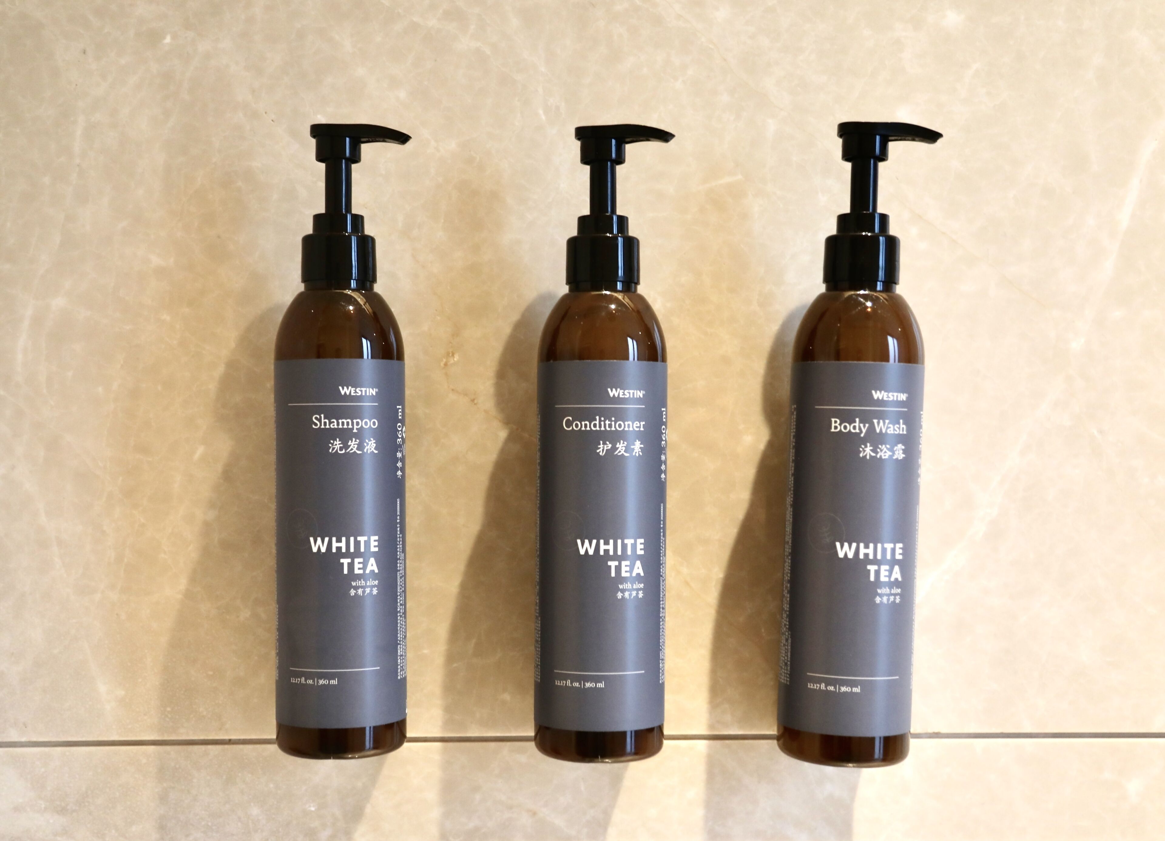 Três frascos de shampoo, condicionador e gel de banho Westin White Tea.