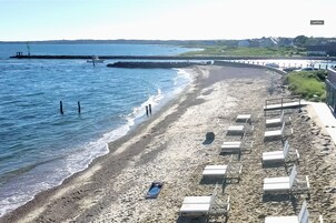 Praia particular, areia branca, espreguiçadeiras, guarda-sóis 