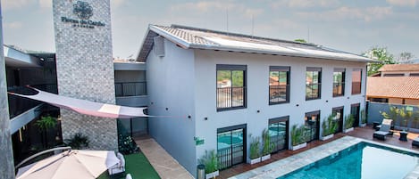 Um edifício moderno com piscina, área de estar ao ar livre e uma placa com a inscrição