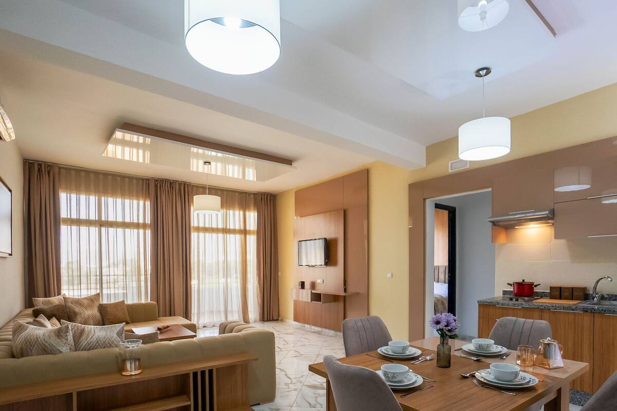 Uma sala de estar moderna com sofá, mesa de jantar e cozinha.