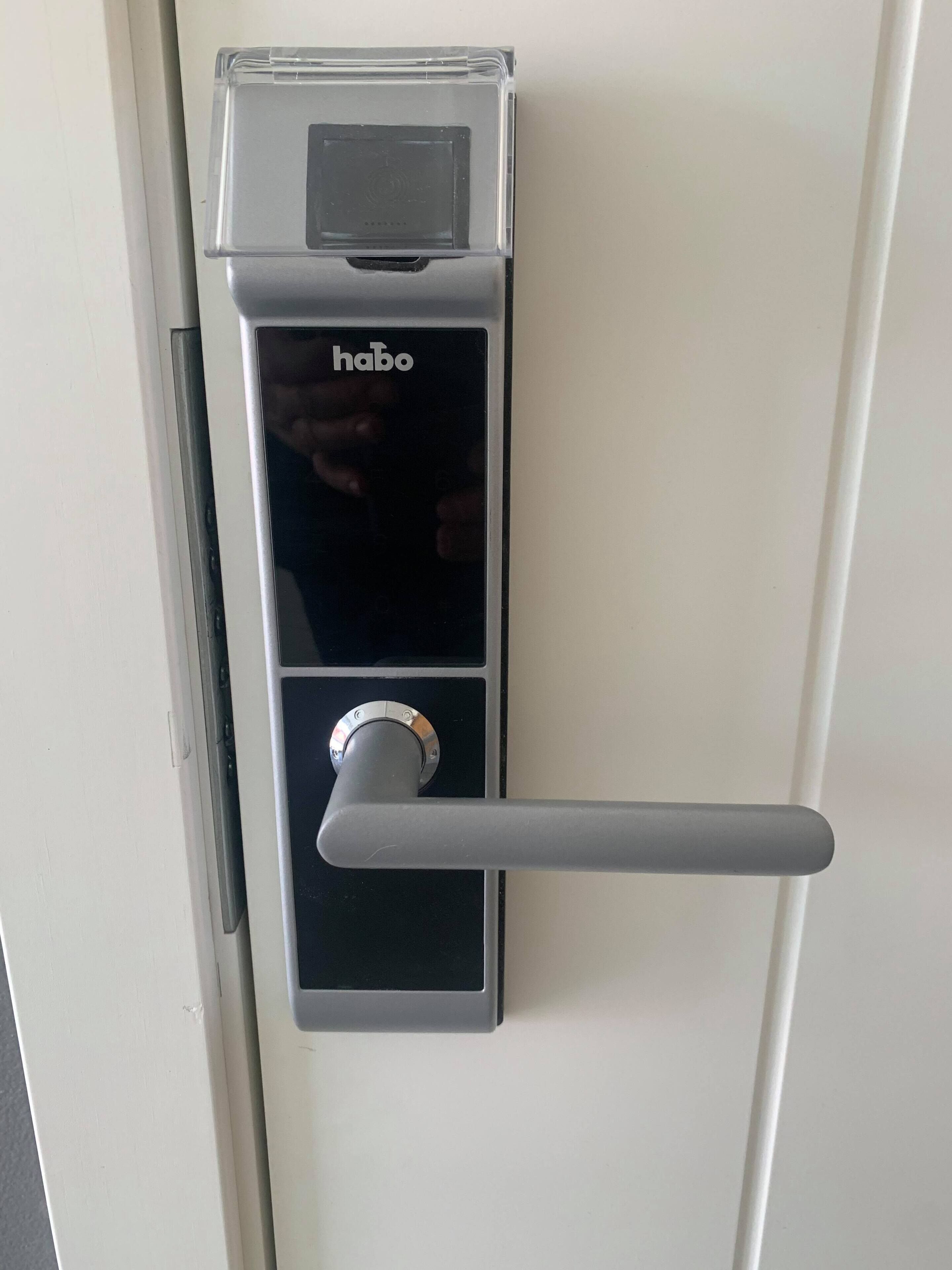 Uma porta com fechadura eletrônica moderna e um buraco para chave.