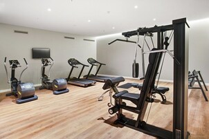 Uma academia com esteiras, elípticos e equipamentos de musculação.
