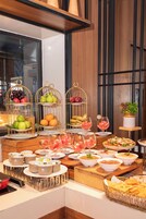 Buffet com diversos alimentos e apresentações de frutas.