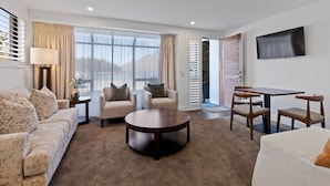 Uma sala de estar moderna com um sofá, poltronas, uma mesa de centro e um espaço de jantar com mesa e cadeiras.