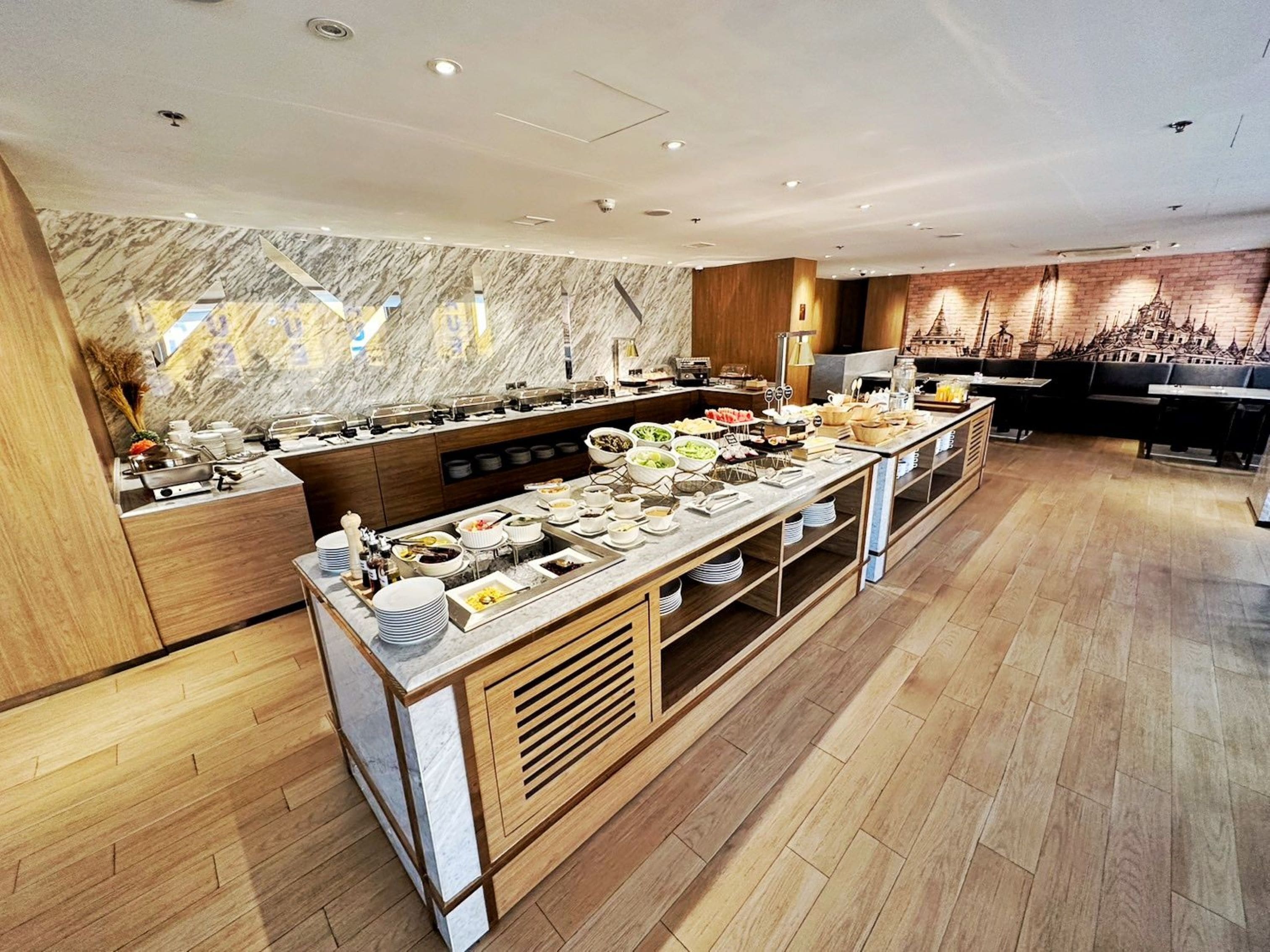 Um buffet de café da manhã moderno, com paredes de mármore e detalhes em madeira.