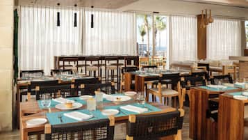 Um restaurante com várias mesas e cadeiras dispostas para refeições.
