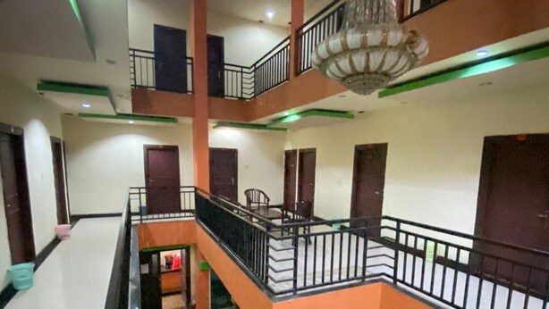 Um interior em vários níveis, com uma escadaria central, varandas e um candelabro.