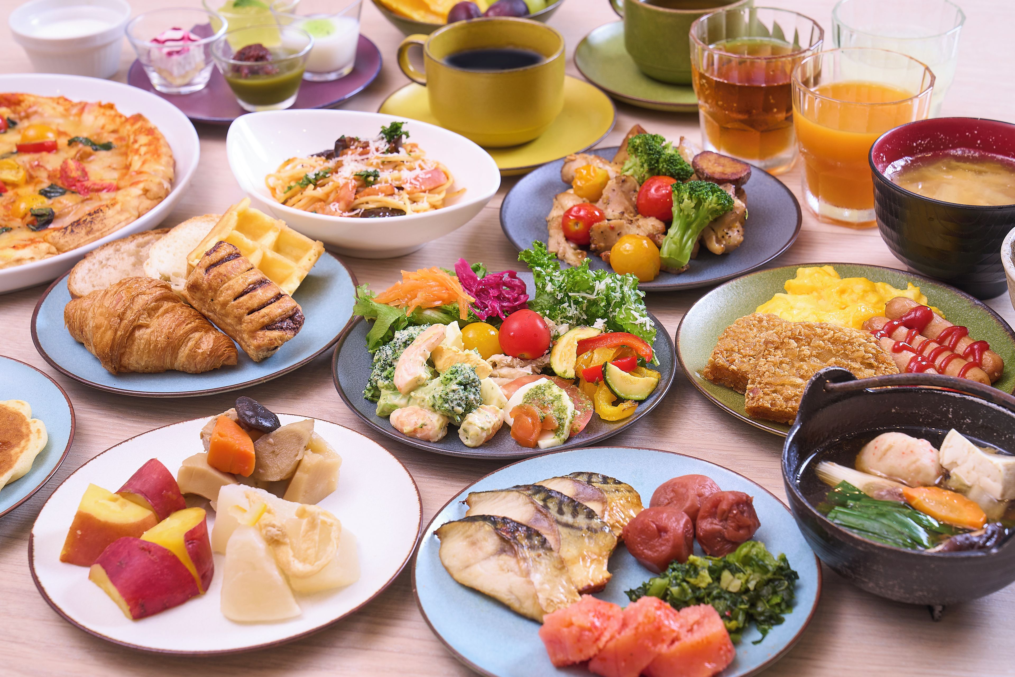 Diversos pratos em uma mesa, incluindo pizza, massa e saladas.