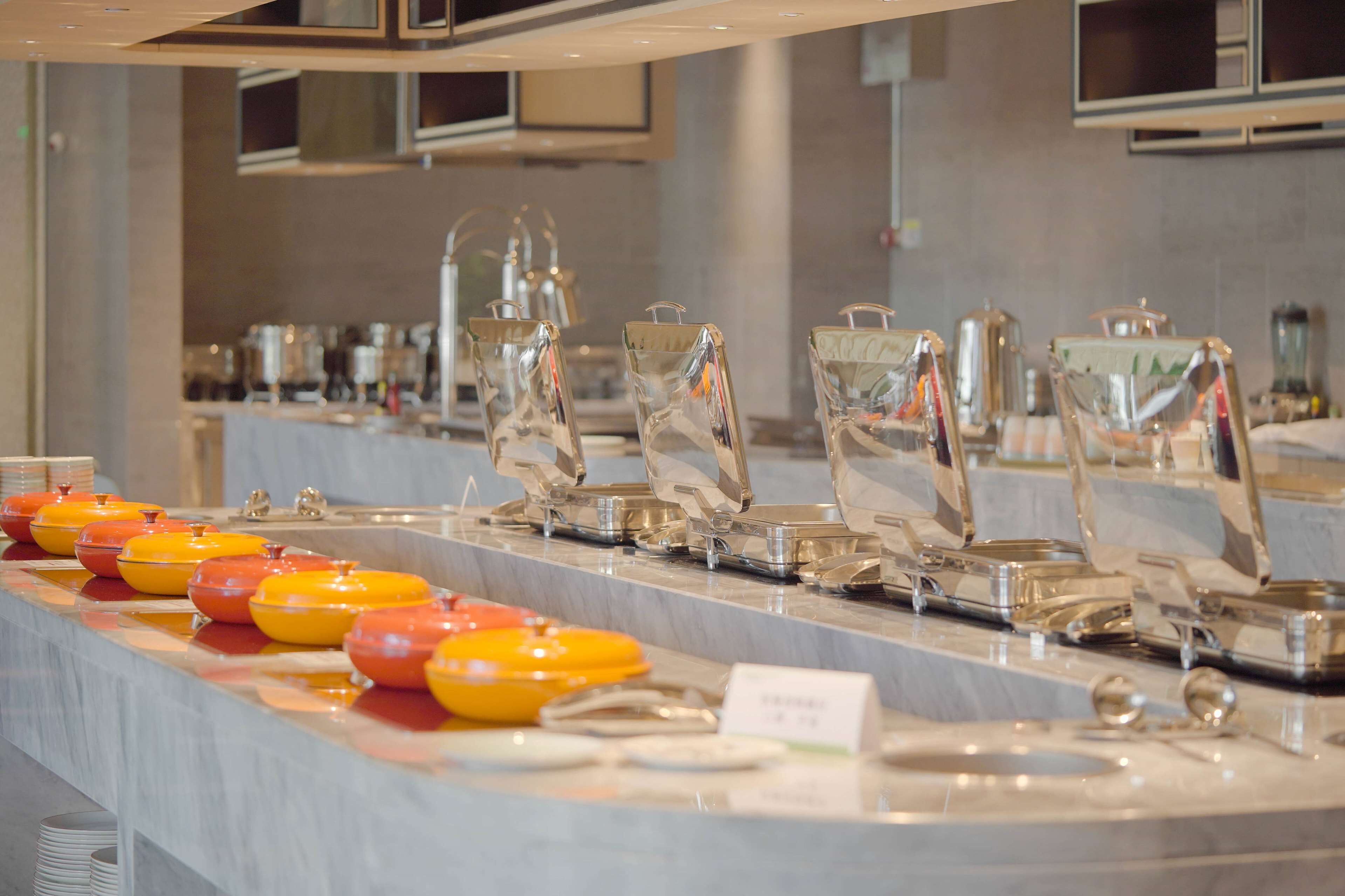 Disposição de buffet com recipientes de vidro transparente e bancada de mármore.