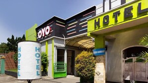 Um hotel com design moderno, exibindo uma placa de destaque 'OYO' e uma placa 'HOTEL'.