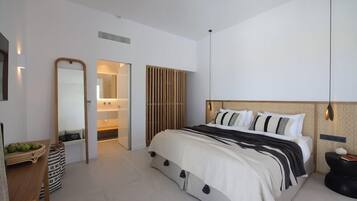 Quarto moderno com cama grande, mesas de cabeceira, guarda-roupa e espelho.