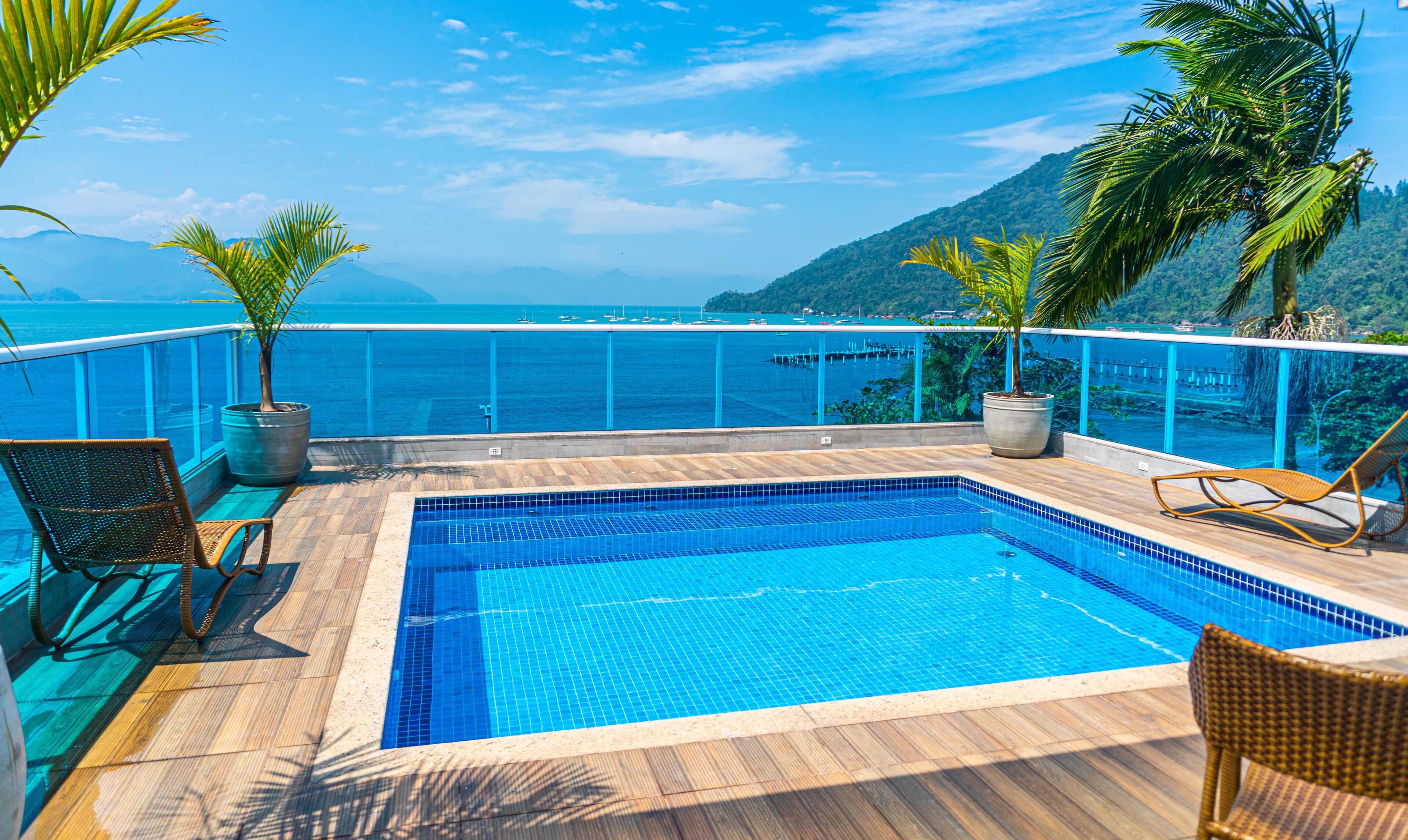 Uma área de piscina com vista para o mar e montanhas.
