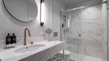 Uma casa de banho moderna com duas lavatórios, um espelho grande e uma cabine de duche de vidro.