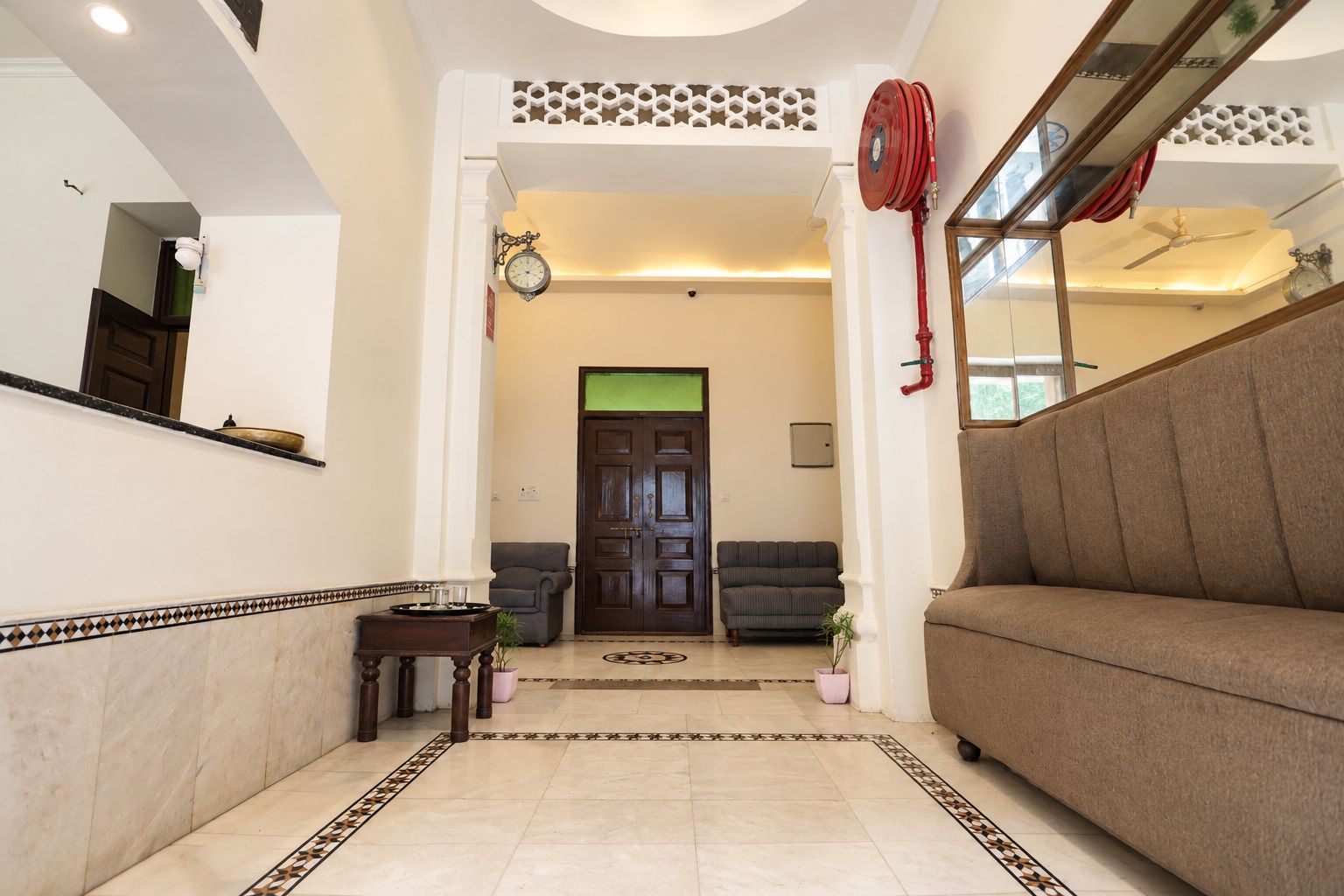 Sala de estar com sofá, mesa de centro e lareira. Há uma porta que dá para outro quarto e uma janela com vista.