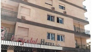 Um hotel de vários andares com uma placa indicando "Crystal Hotel" acima da entrada.