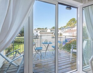 Varanda com vista para uma área residencial, com mesa e cadeiras.