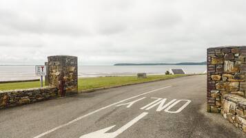 Uma estrada com uma placa de 'Proibido o Sentido' e vista para o mar.