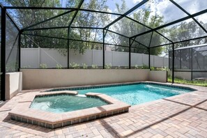 Piscina com hidromassagem, rodeada por um alpendre coberto.