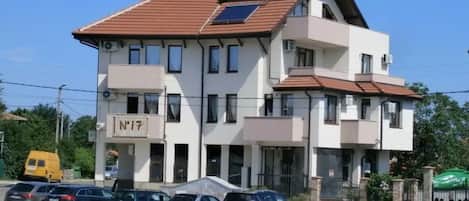 Um edifício de vários andares com telhado plano e painéis solares.