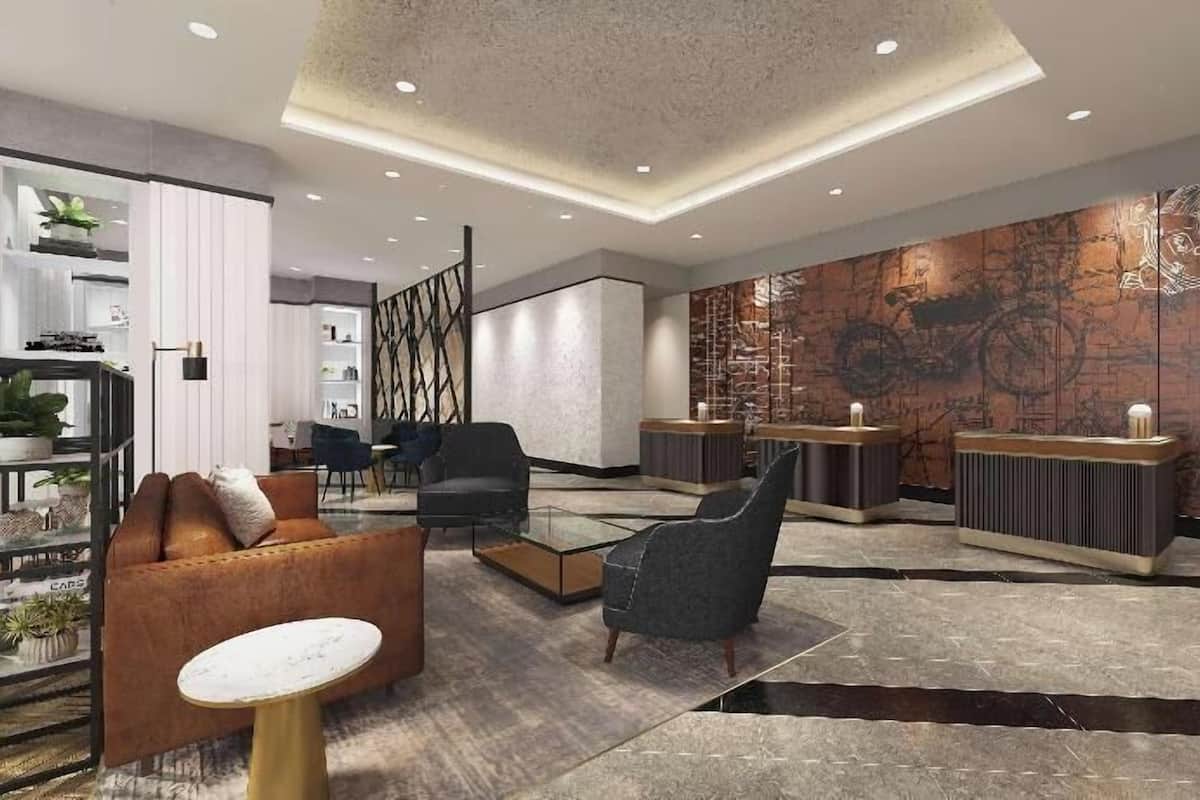 Um lobby moderno com assentos, balcão de recepção e um painel decorativo.