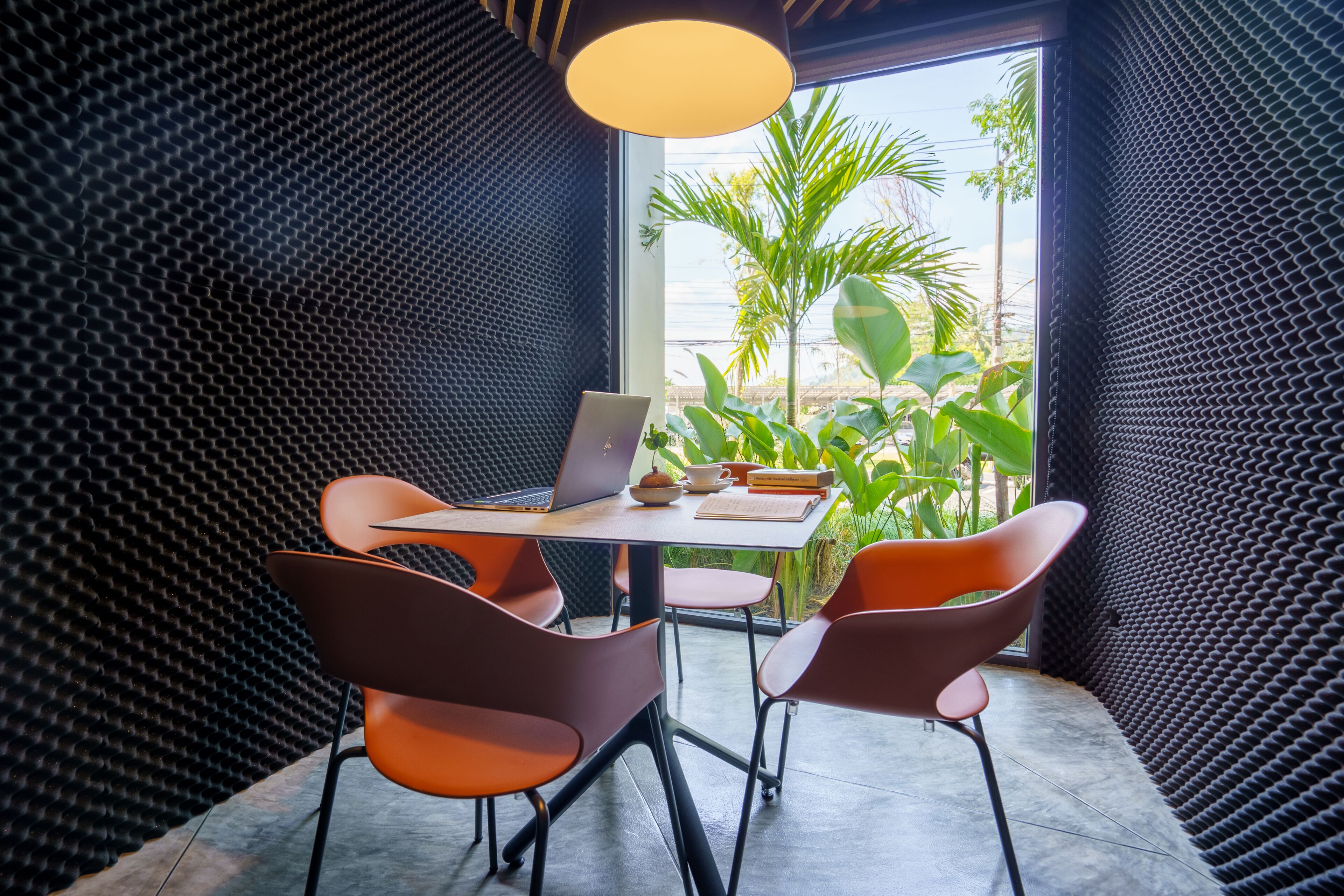 Um interior moderno com uma mesa, cadeiras e um laptop.