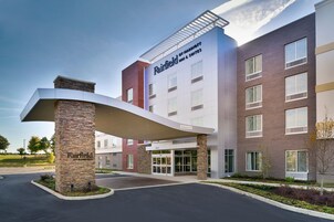 Um hotel Fairfield Inn & Suites com design moderno, destacando uma entrada imponente e uma galeria coberta.