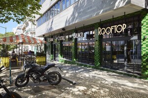 Um bar no terraço com uma placa que diz 'ROOFTOP' e 'COCKTAILS BRUNCH'.
