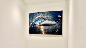 Fotografia de uma onda em um corpo d'água, exposta em uma parede.