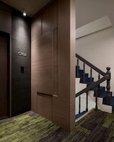 Um interior moderno com escada, paredes revestidas de madeira e piso carpeteado.