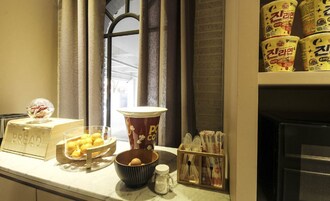 Uma bancada de cozinha com uma máquina de fazer pão, um recipiente com limões, uma xícara de café e um saleiro.