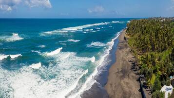 Na praia, espreguiçadeiras, guarda-sóis de praia, toalhas de praia