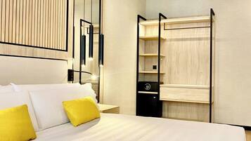 Quarto de hotel moderno com uma cama grande, um guarda-roupa e um espelho.