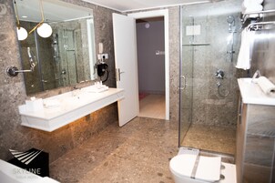Um banheiro moderno com toucador branco, um espelho grande, box de vidro e vaso sanitário.