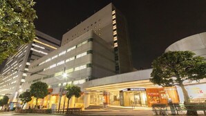Um hotel moderno com vários andares, entrada destacada e um restaurante chamado 'OUTBACK Steakhouse' no nível térreo.