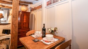 Uma sala de jantar com uma mesa de madeira posta para dois, um globo e uma estante de livros.