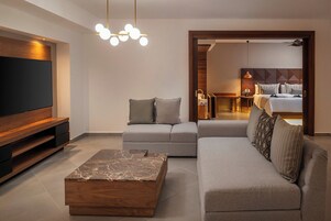 Uma sala de estar moderna com sofá seccional, mesa de centro e TV de tela plana.