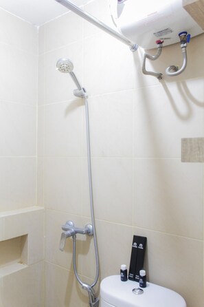 Casa de banho com chuveiro, sanita e porta-toalhas.