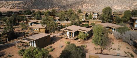 Um resort no deserto com vários edifícios de dois andares, cada um com teto plano e grandes janelas.