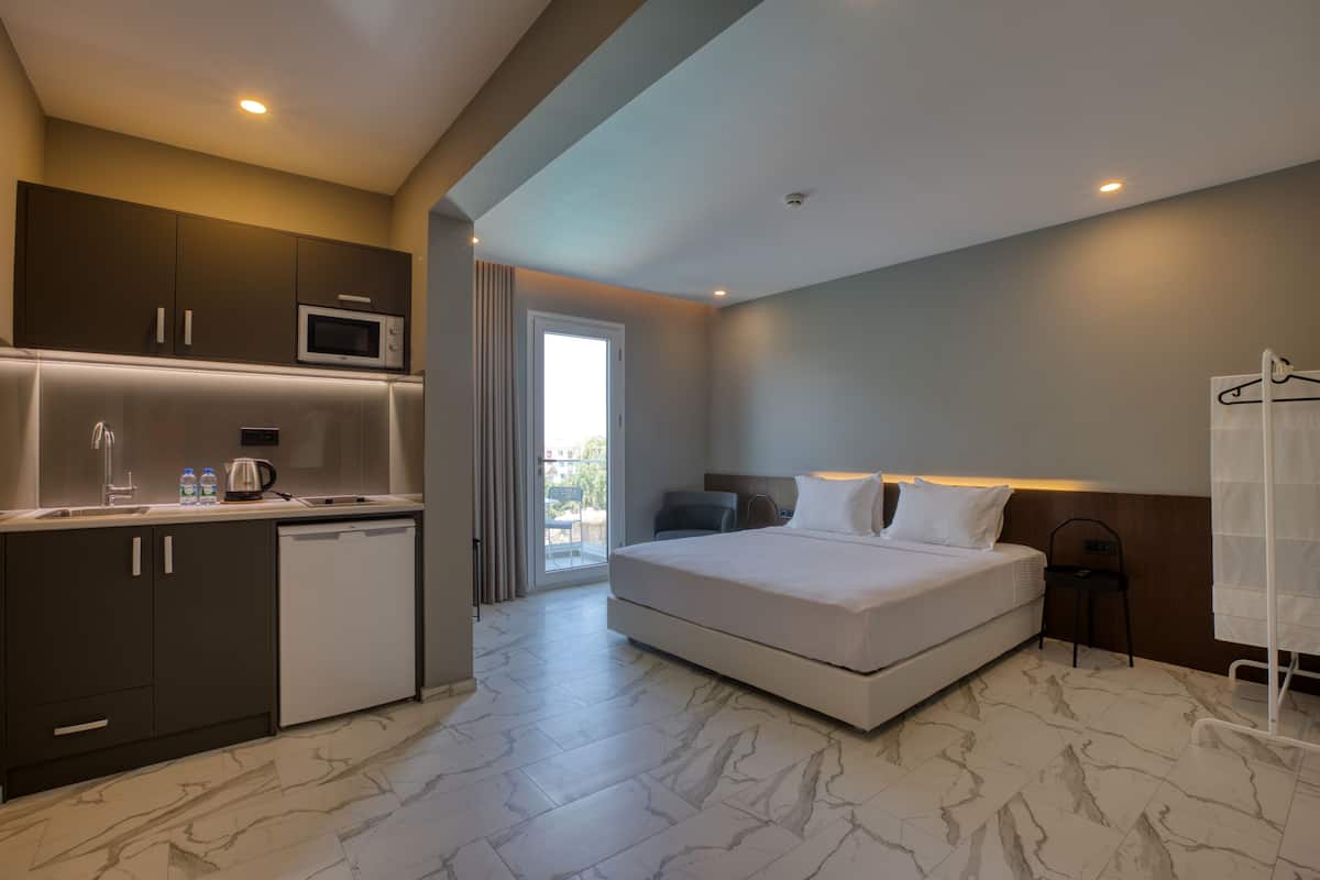 Quarto de hotel moderno com uma cama, pequeno espaço de cozinha e vista para o exterior.