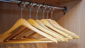 Um porta-roupas de madeira com várias peças.