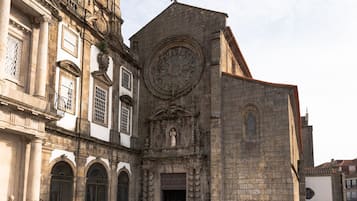 Um edifício histórico com uma grande janela circular e uma torre do sino.