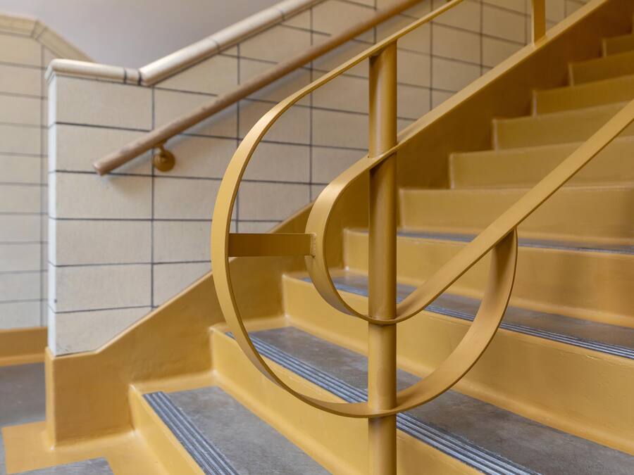 Uma escada com guarda-mão circular e corrimão de metal.