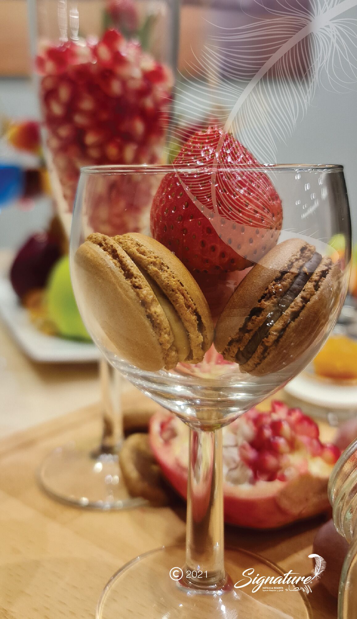 Um copo com macarons e uma morango.