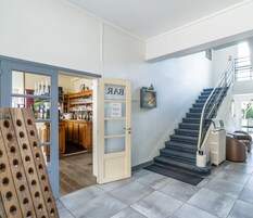 Um interior moderno com escadaria, área de bar e estrutura de madeira com aberturas.
