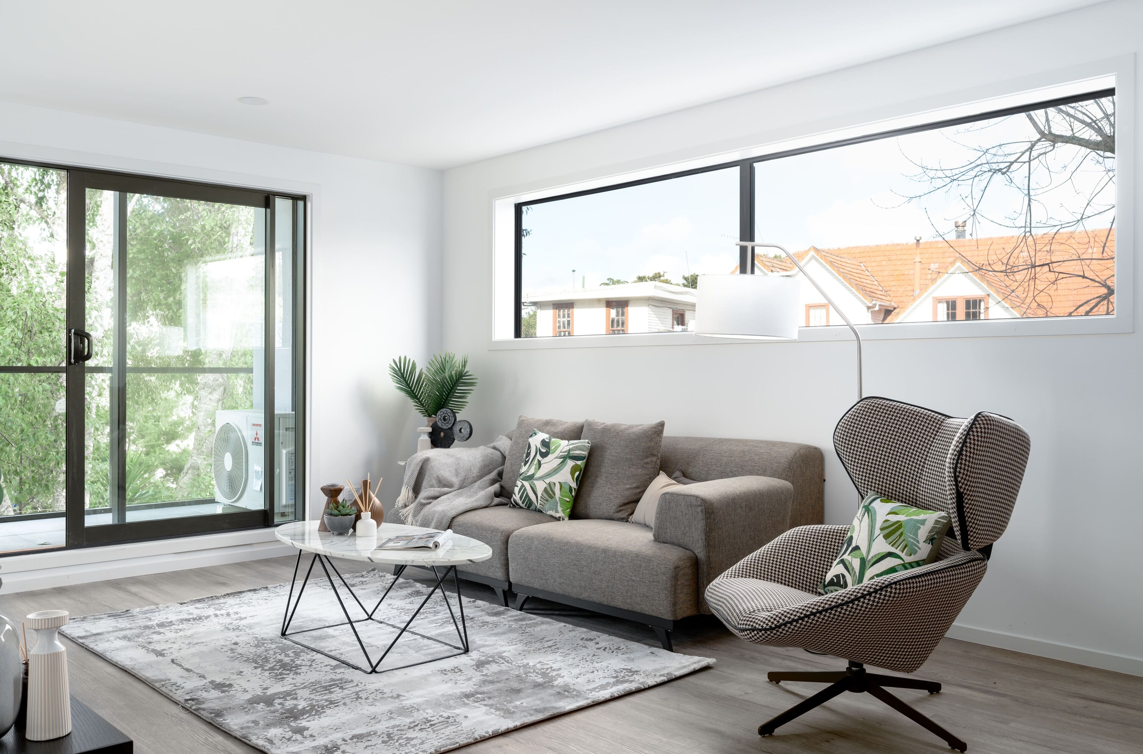 Uma sala de estar moderna com sofá, poltrona e mesa de centro.