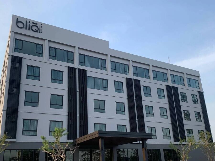 Um hotel moderno com fachada plana, várias janelas e uma área de entrada imponente.