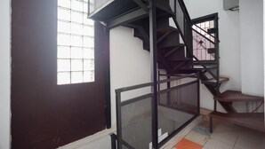 Uma escadaria com grades de metal e uma porta marrom.