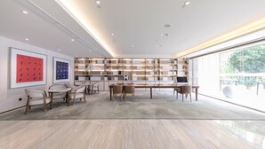Um interior moderno com uma grande estante, área de estar e um amplo janelão.