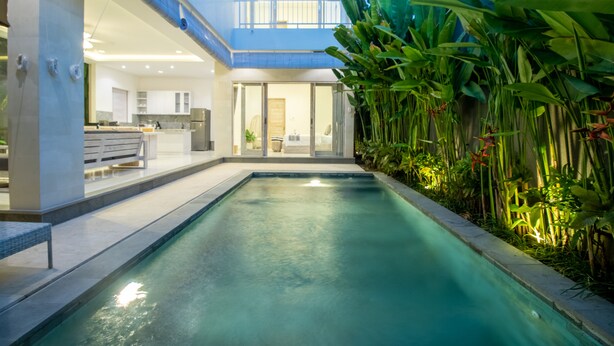 Uma casa moderna com piscina, varanda e um jardim bem cuidado.